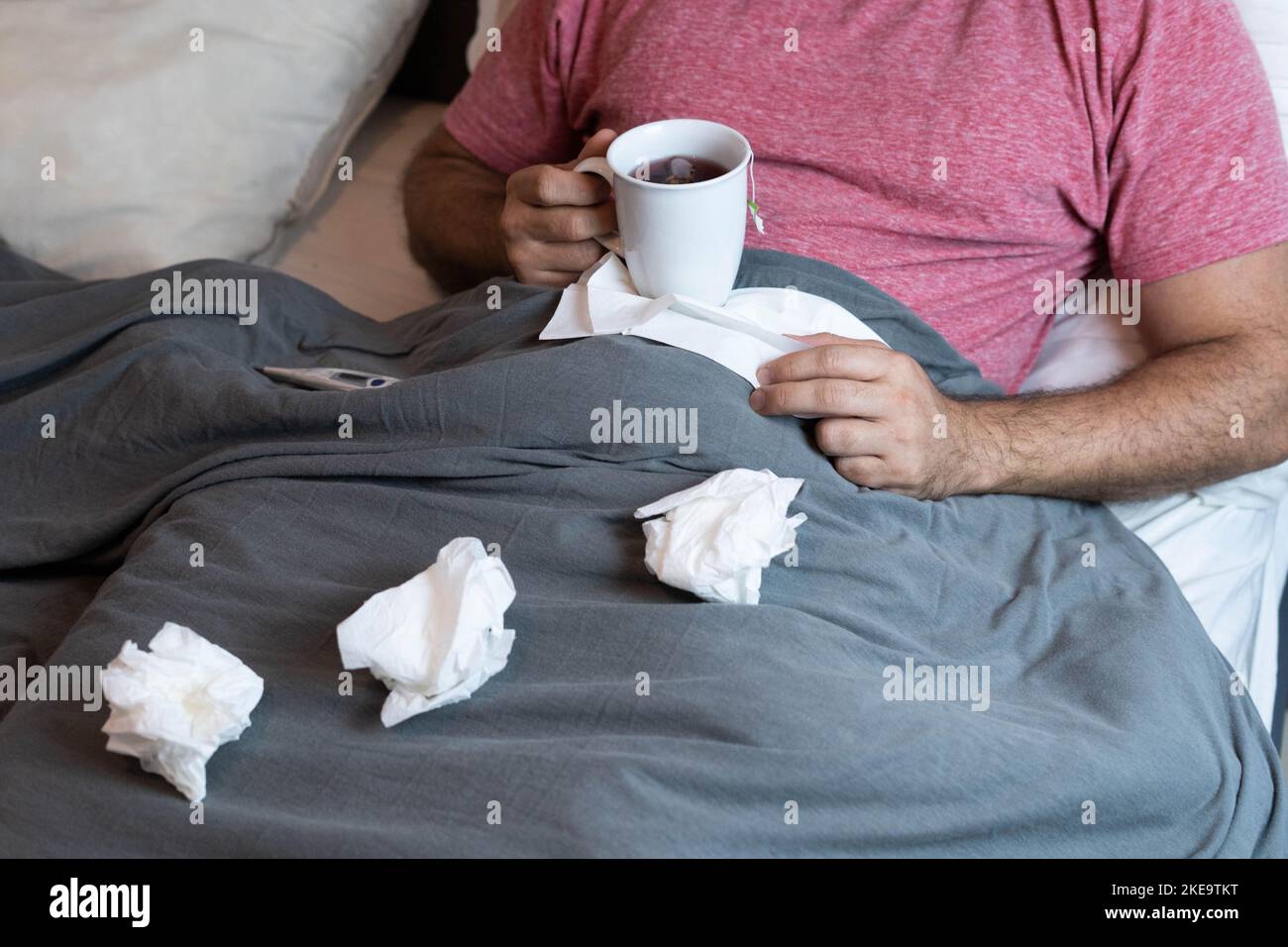 man in bed sick with coronavirus drinking a cup of tea Stock Photo - Alamy
