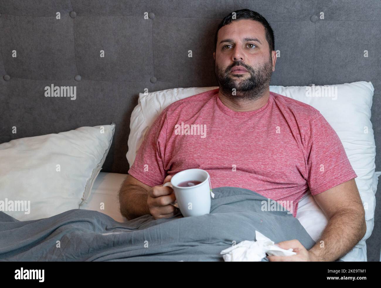 man in bed sick with coronavirus drinking a cup of tea Stock Photo - Alamy