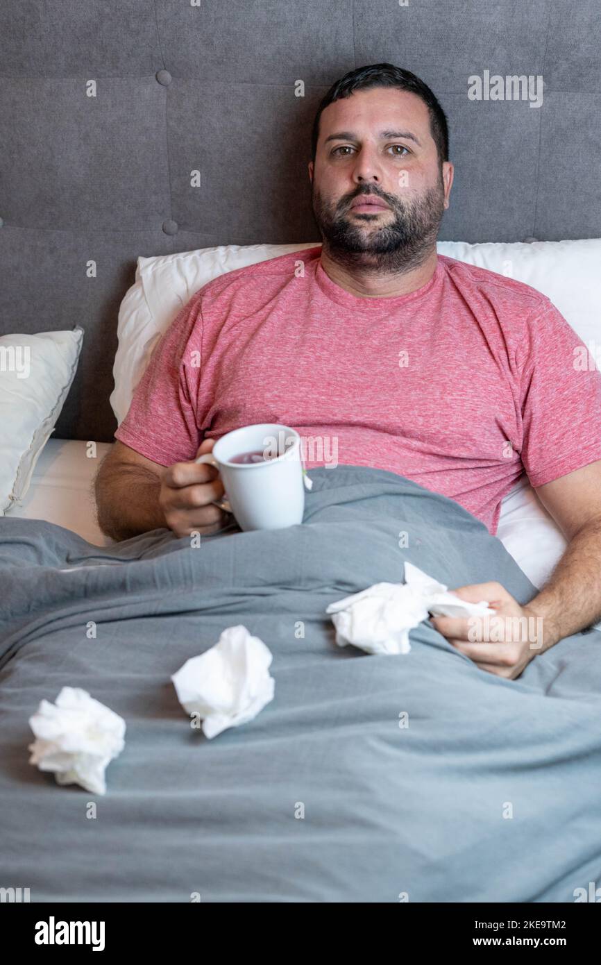 man in bed sick with coronavirus drinking a cup of tea Stock Photo - Alamy
