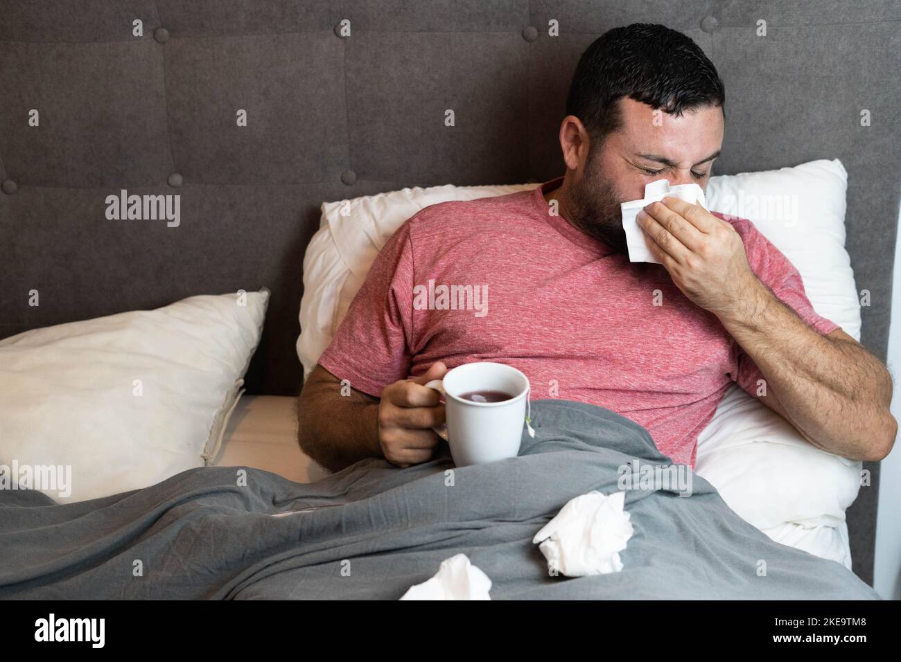 man in bed sick with coronavirus drinking a cup of tea Stock Photo - Alamy