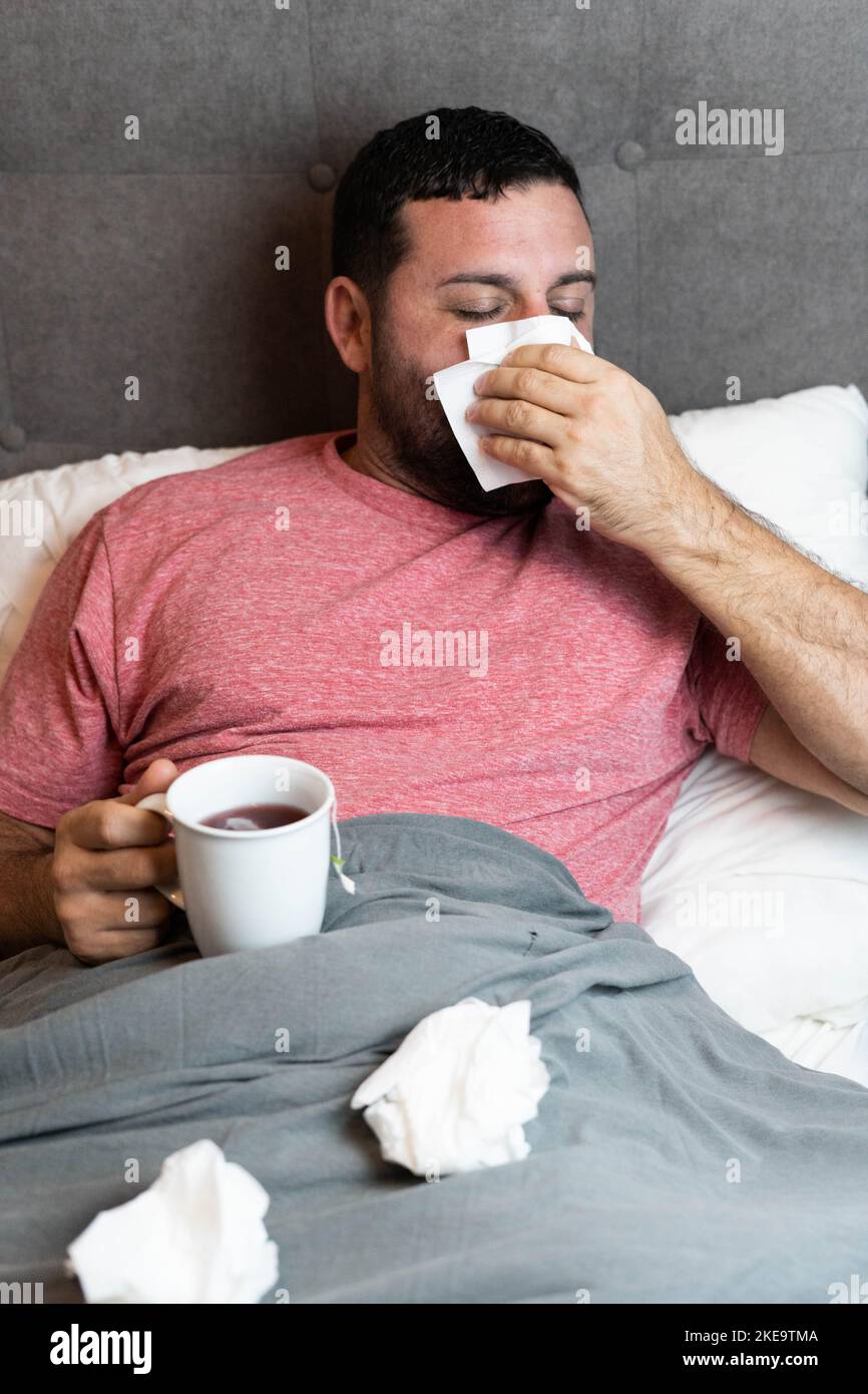 man in bed sick with coronavirus drinking a cup of tea Stock Photo - Alamy