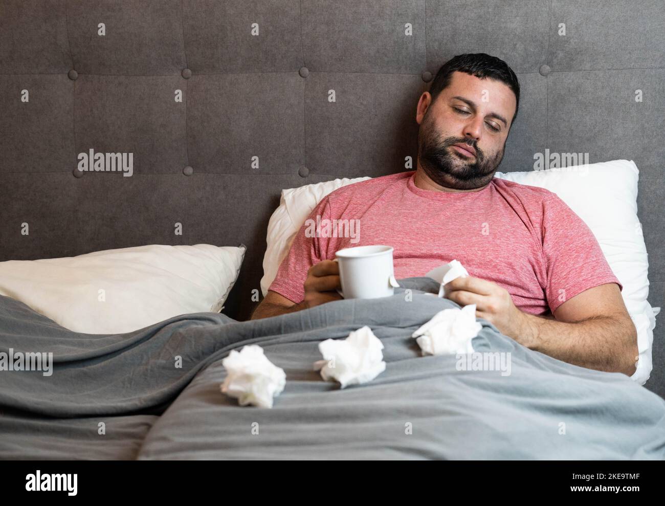 man in bed sick with coronavirus drinking a cup of tea Stock Photo - Alamy