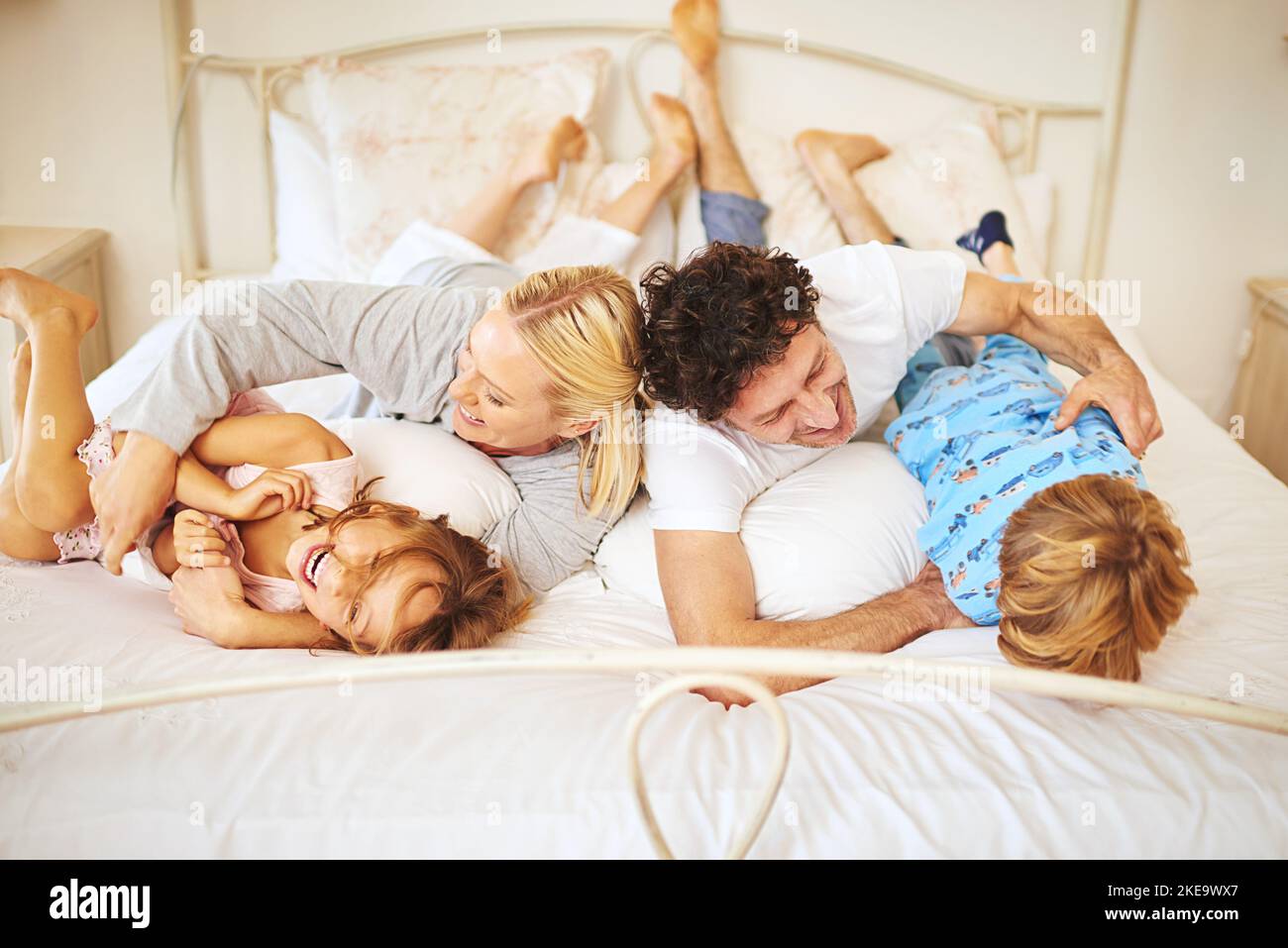 Tickle attack. a family having some fun together in the morning at home ...