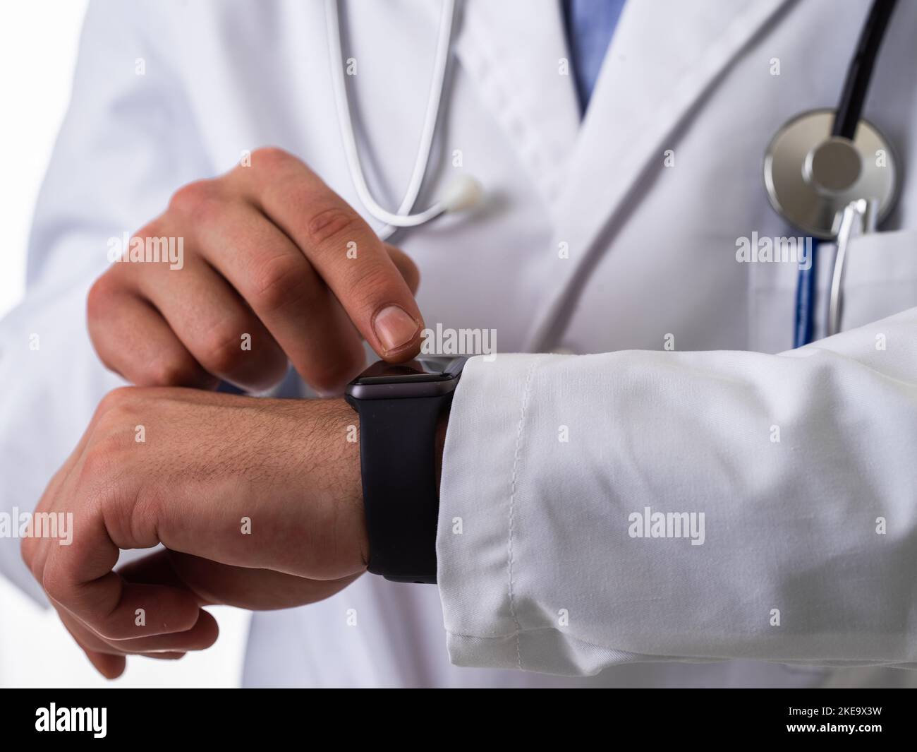 Doctor in suit with stethoscope using smart watch while isolated on ...