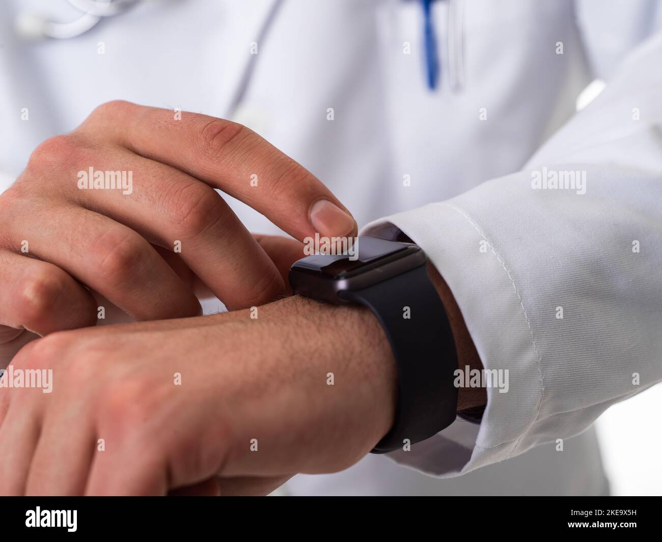 Doctor in suit with stethoscope using smart watch while isolated on ...