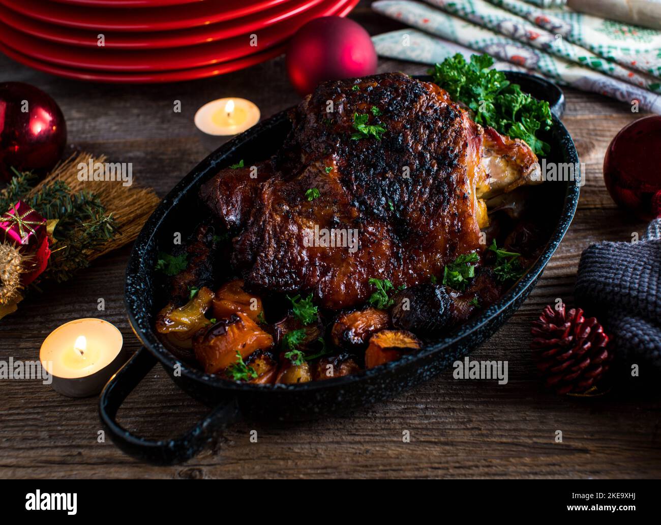 Christmas roast on wooden table with tea lights. Roasted turkey shanks ...