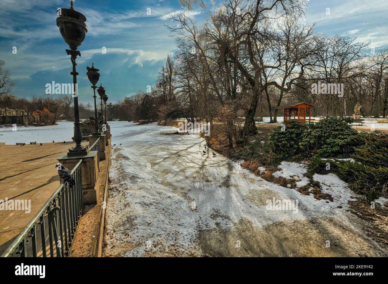 The scattered snow under blue cloudy sky in Lazienki Krolewskie Park in ...