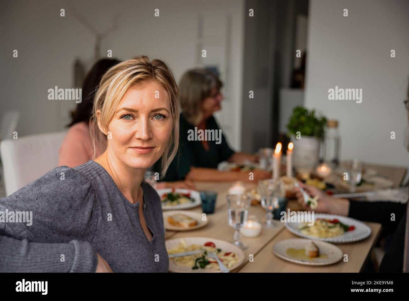 Portrait of woman having dinner with family Stock Photo - Alamy