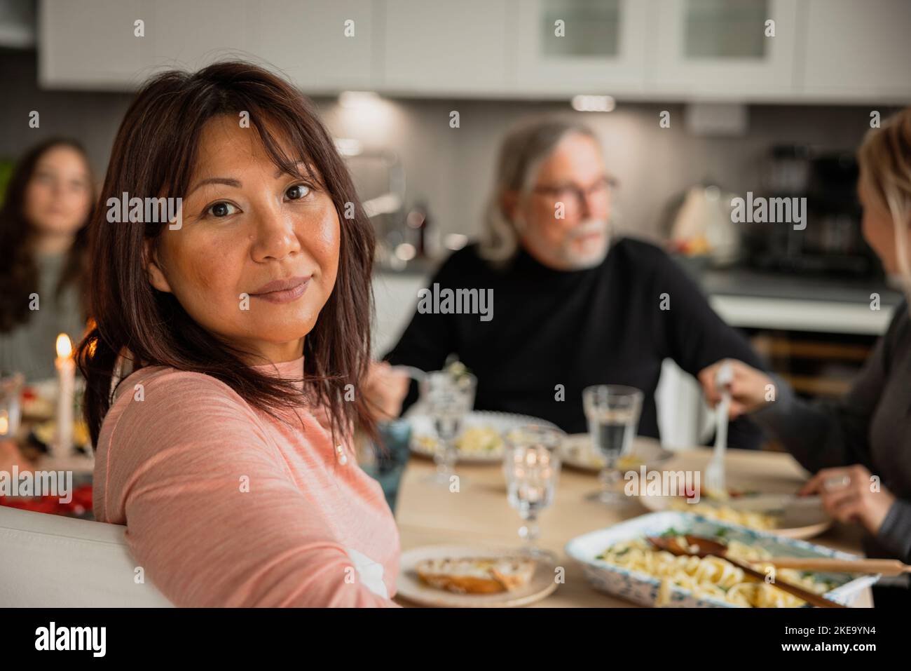 Portrait of woman having dinner with family Stock Photo - Alamy