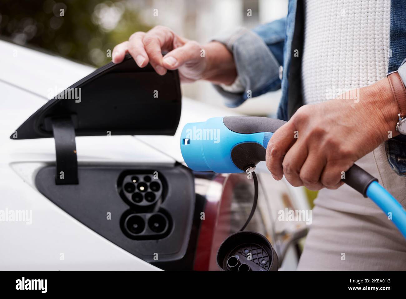 Woman charging electric car Stock Photo - Alamy