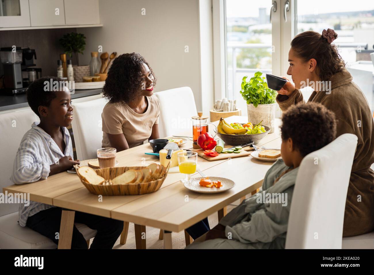Mothers and sons eating breakfast Stock Photo - Alamy