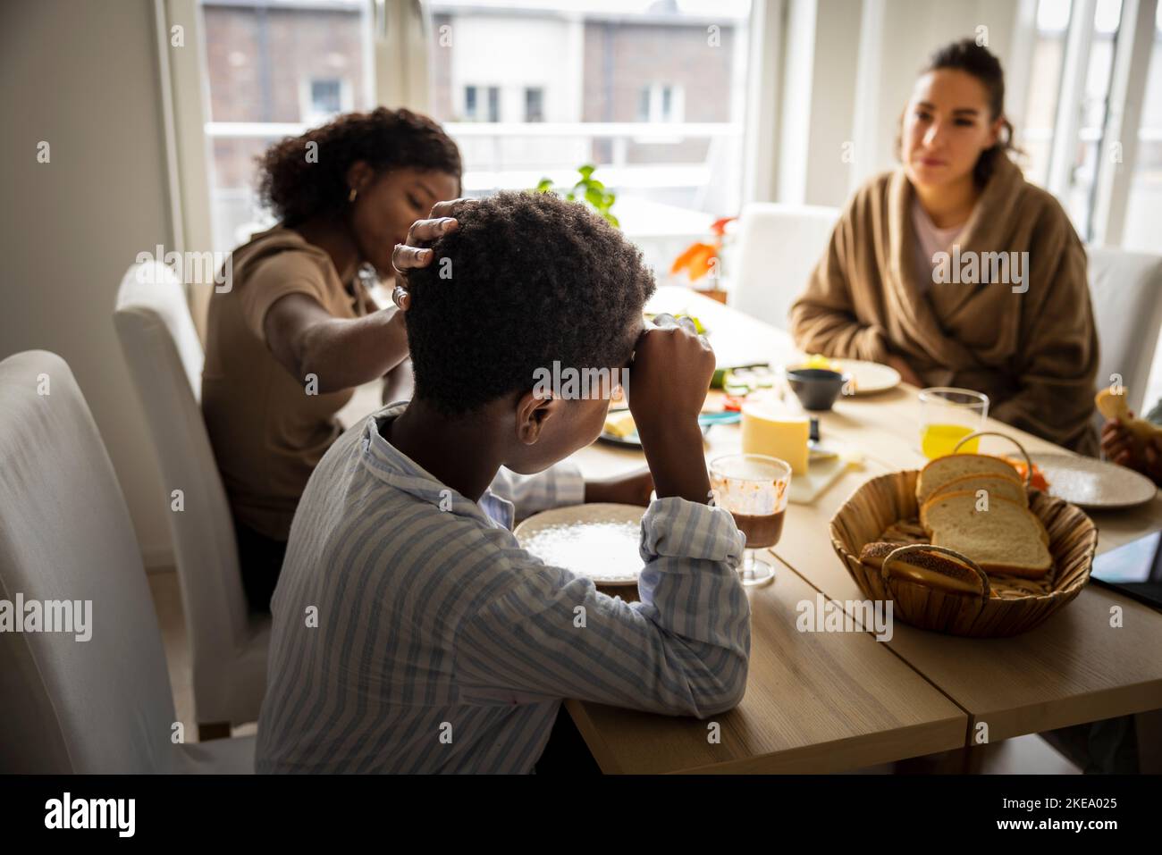 Mothers and sons eating breakfast Stock Photo - Alamy