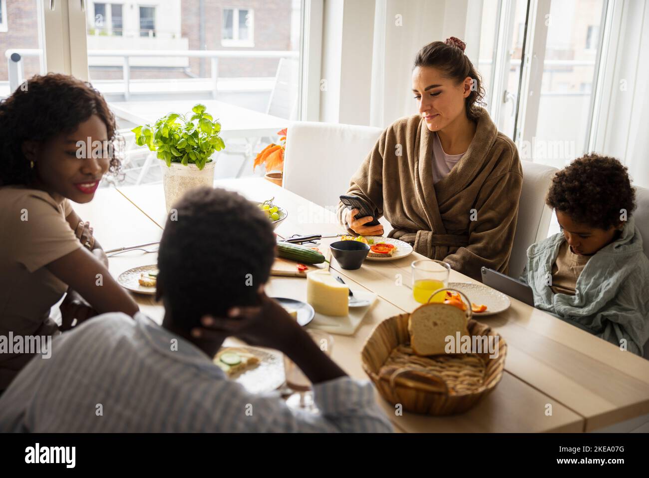 Mothers and sons eating breakfast Stock Photo - Alamy