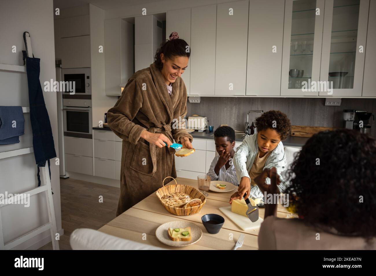 Mothers and sons eating breakfast Stock Photo - Alamy