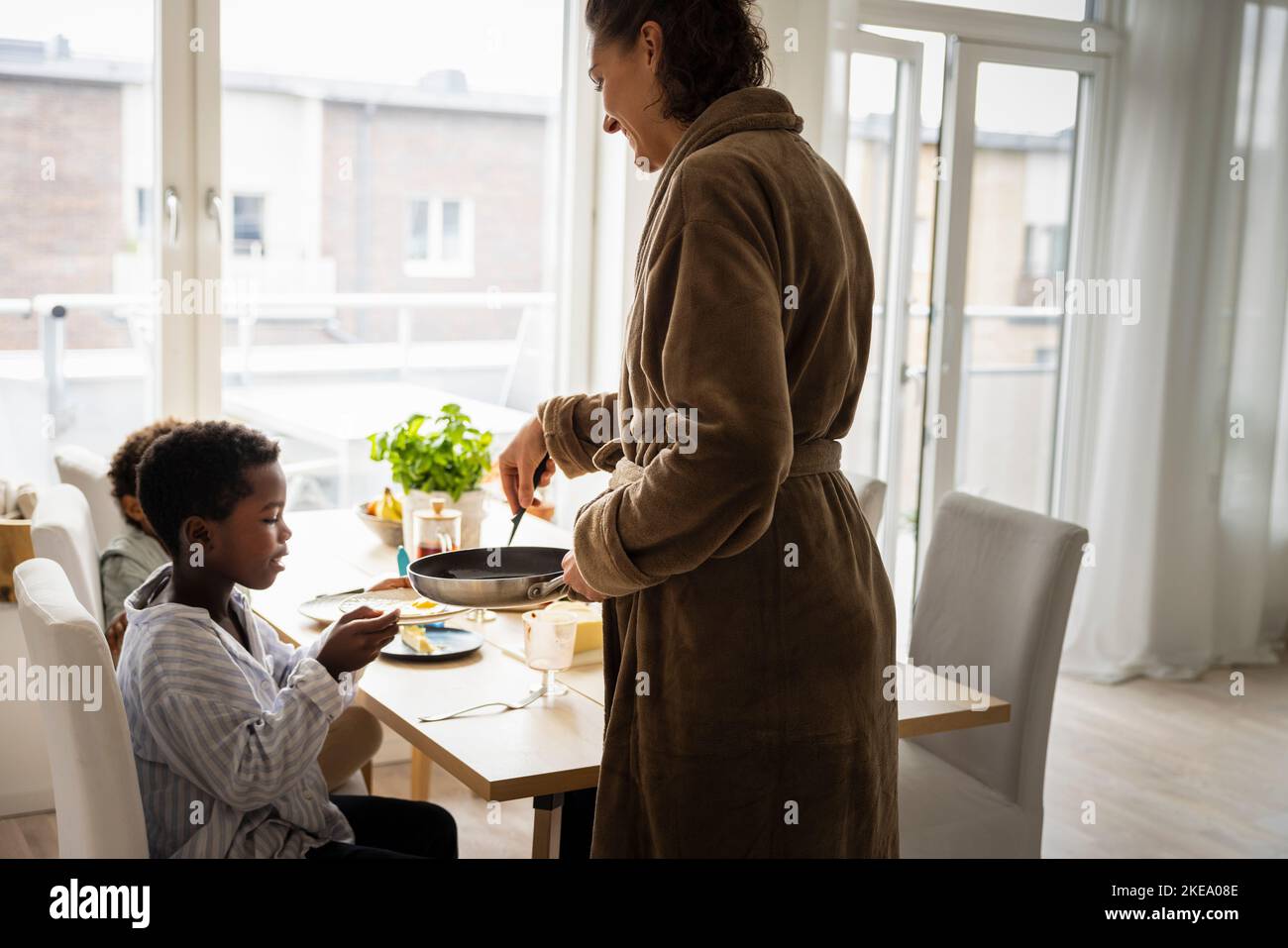 Mother serving breakfast for sons Stock Photo - Alamy