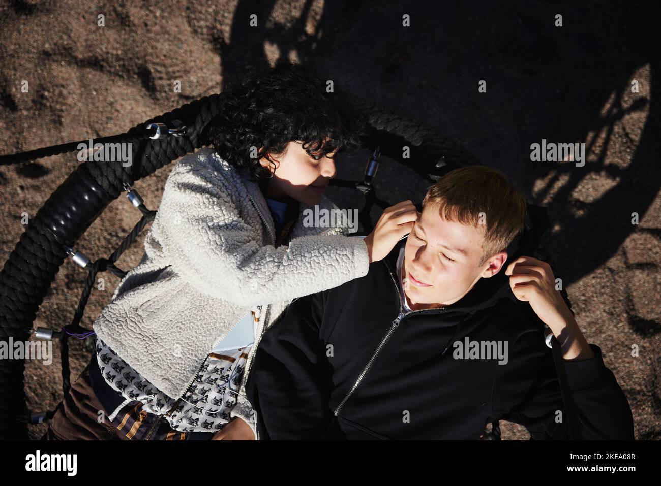 Friends relaxing on swing Stock Photo - Alamy