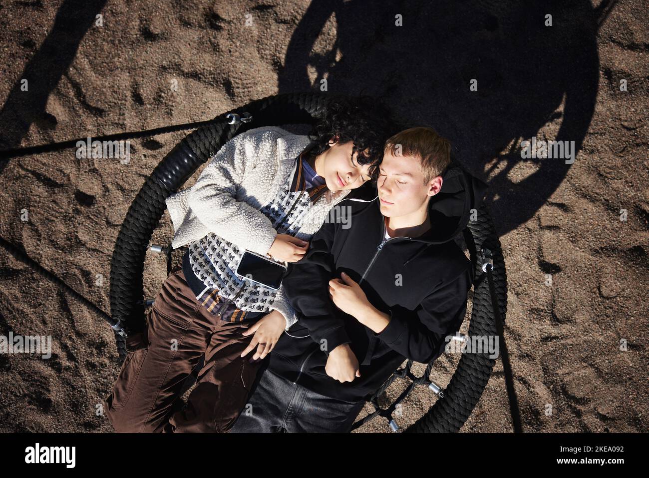 Friends relaxing on swing Stock Photo - Alamy