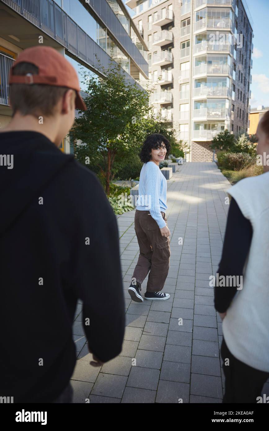 Smiling friends walking together Stock Photo - Alamy