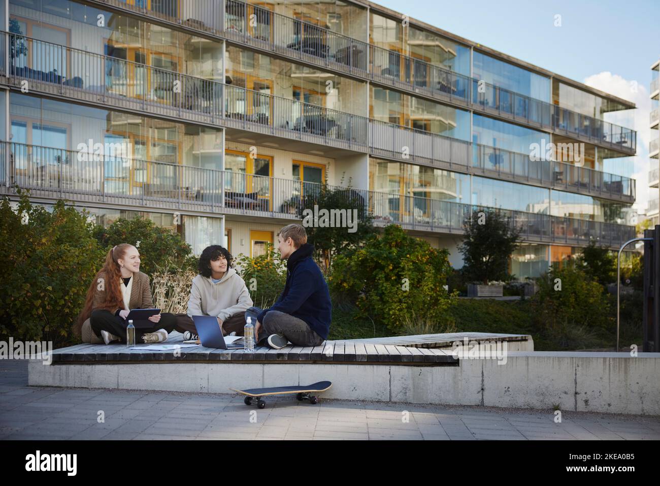 Friends at playground talking Stock Photo - Alamy