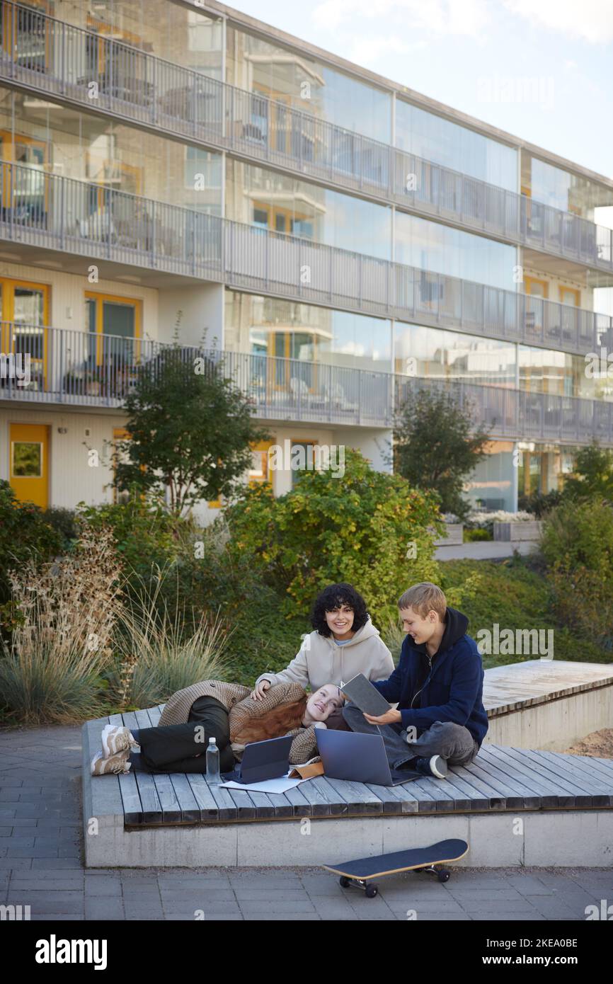 Friends sitting outside together Stock Photo - Alamy