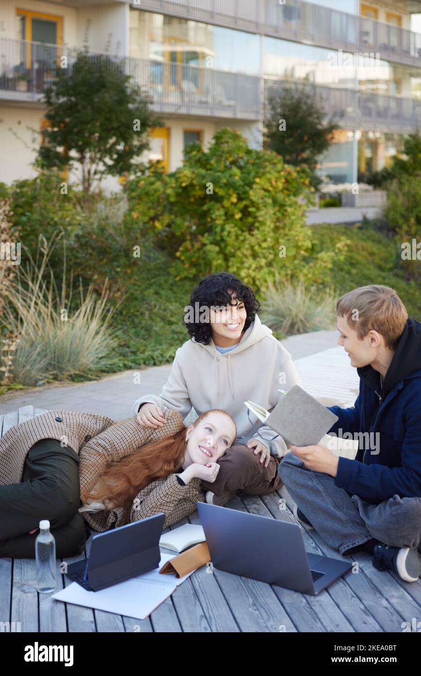 Friends sitting outside together Stock Photo - Alamy