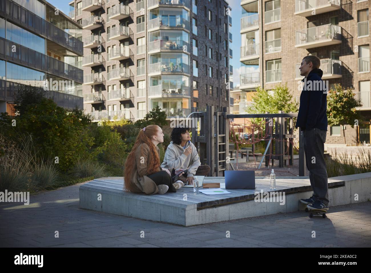 Friends at playground talking Stock Photo - Alamy