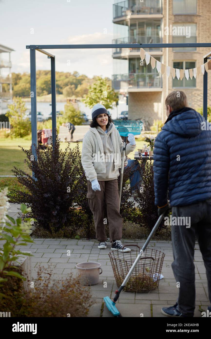 Neighbors tidying communal area together Stock Photo - Alamy