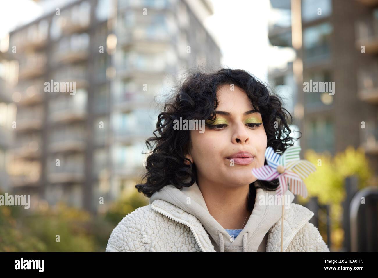 Teenage girl blowing on pinwheel Stock Photo - Alamy