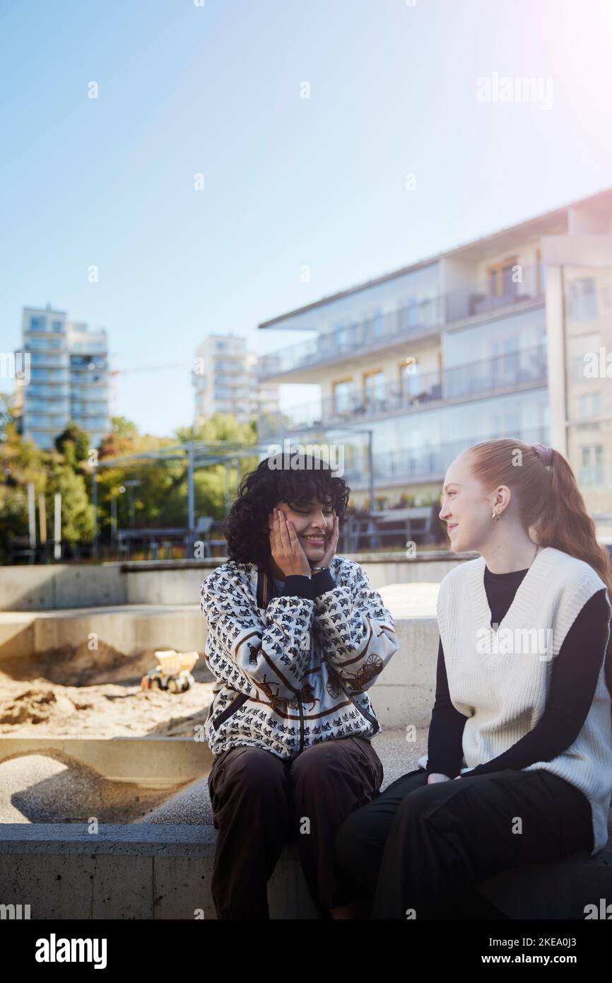 Smiling friends talking together Stock Photo - Alamy