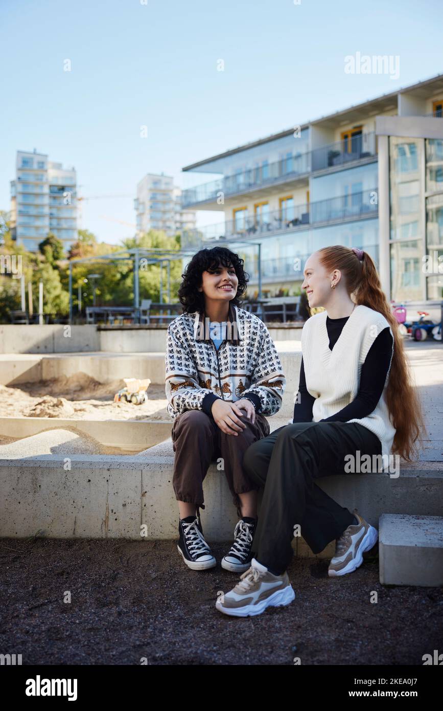Smiling friends talking together Stock Photo - Alamy