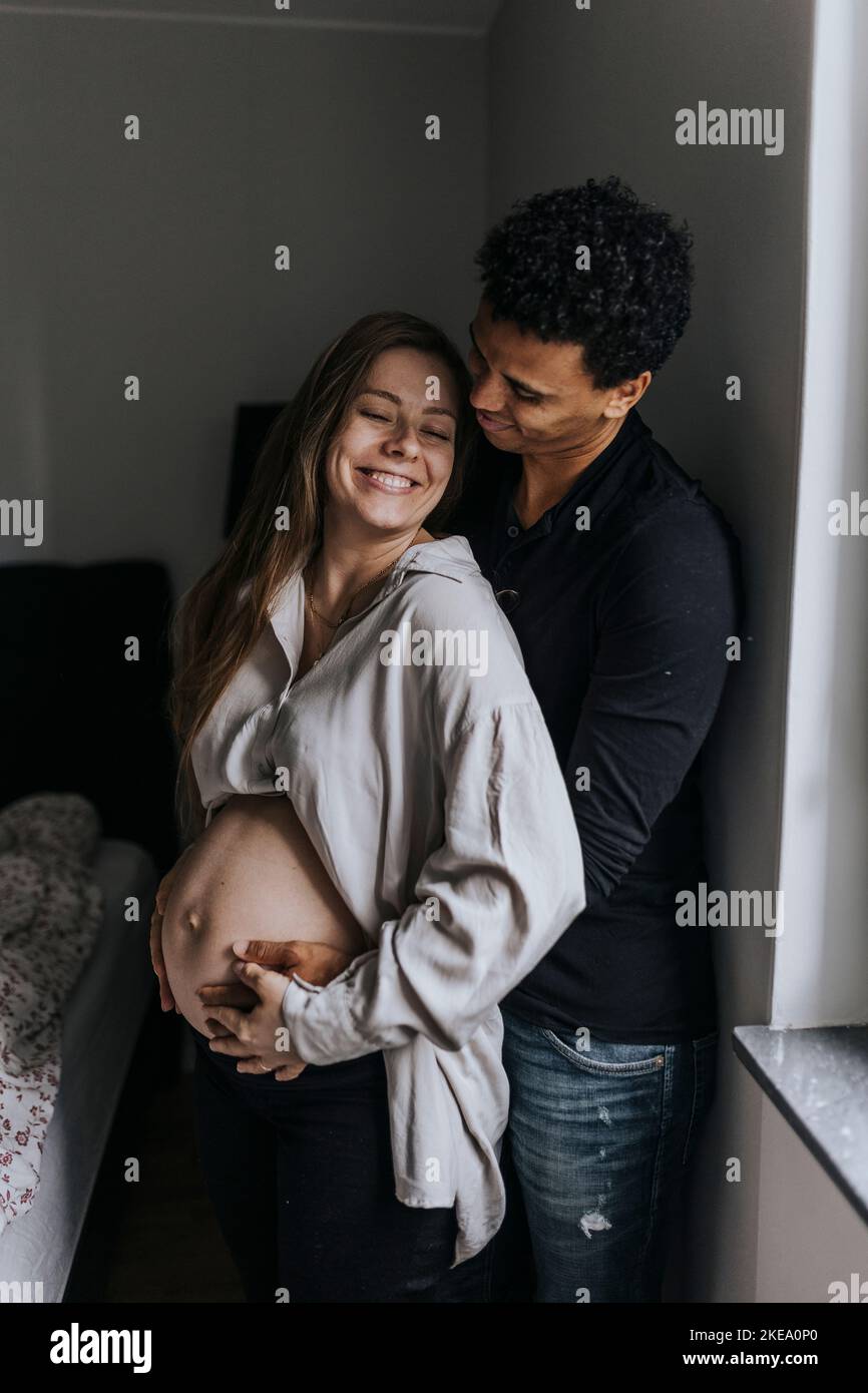 Pregnant woman with partner standing together Stock Photo - Alamy