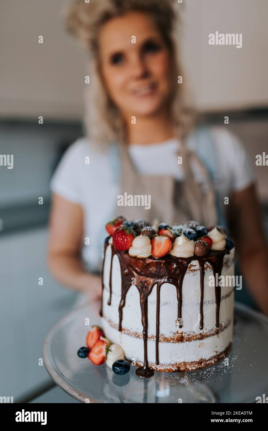 Woman in kitchen with cake Stock Photo - Alamy