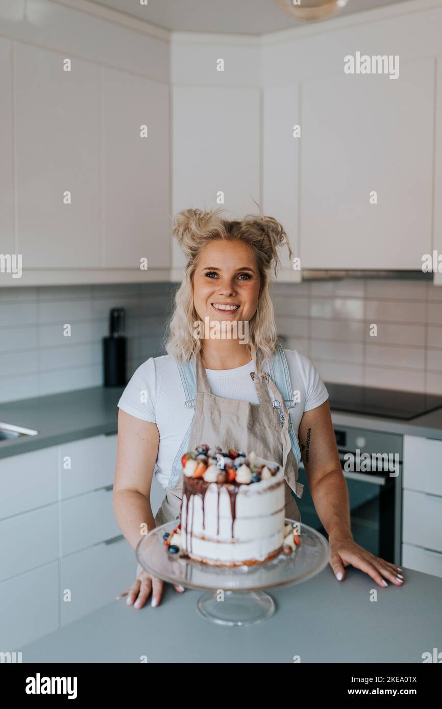 Woman in kitchen with cake Stock Photo - Alamy