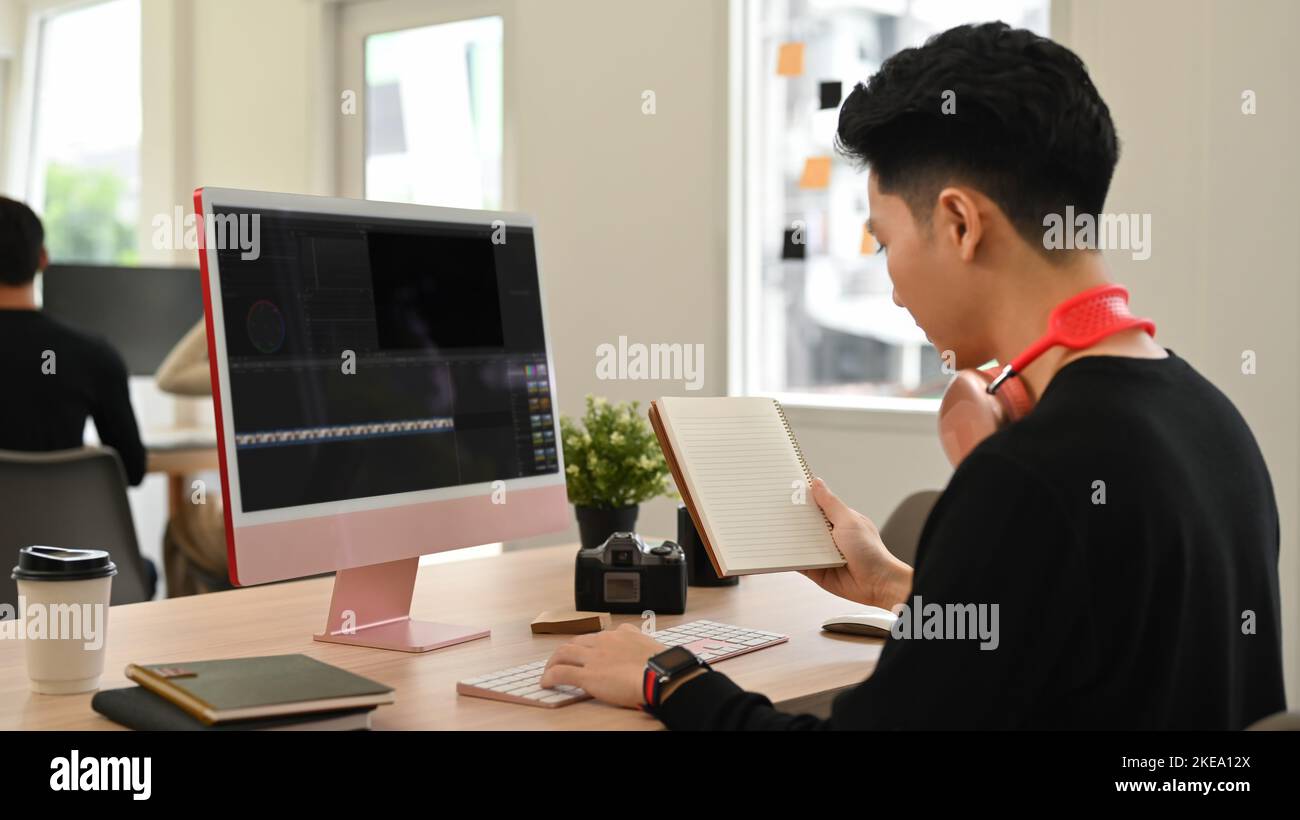 Young male video editor working with footage and sound at modern ...