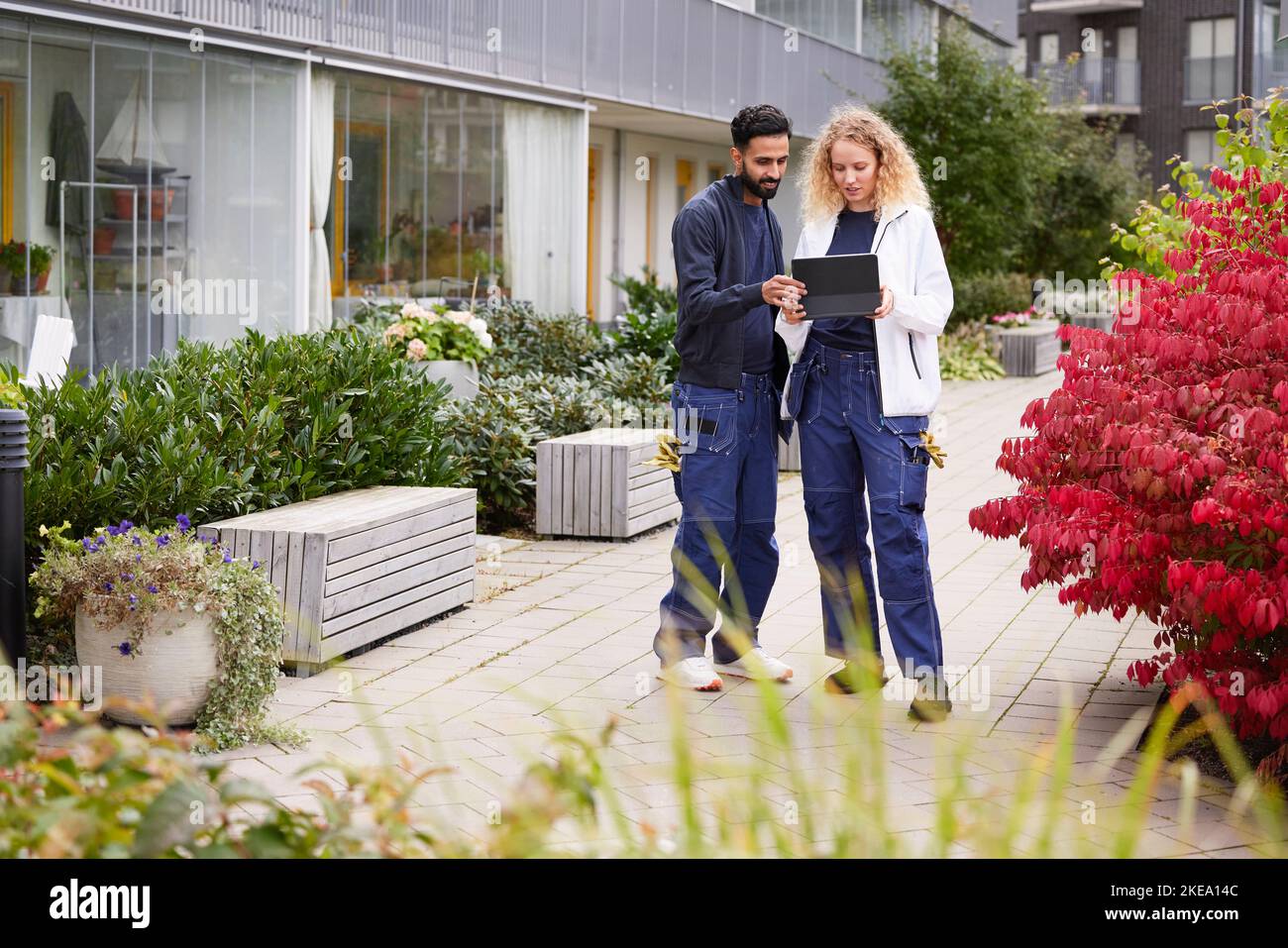 Male and female worker in front of residential building Stock Photo - Alamy