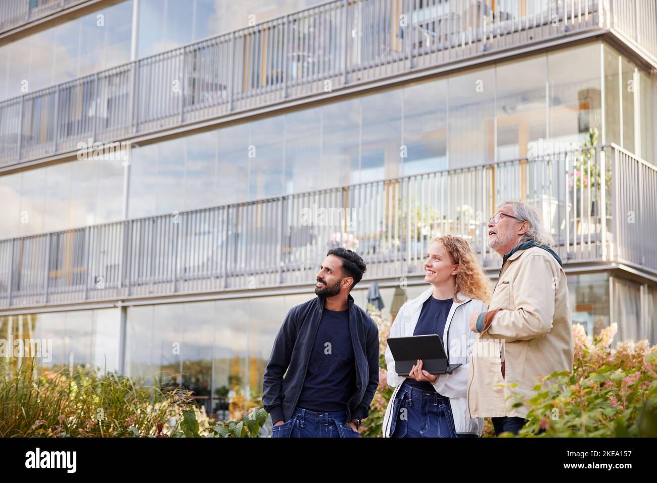 Men and woman with laptop looking at buildings Stock Photo - Alamy