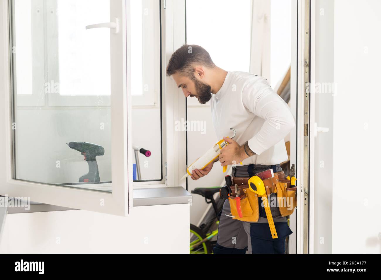 service man installing window with screwdriver Stock Photo - Alamy
