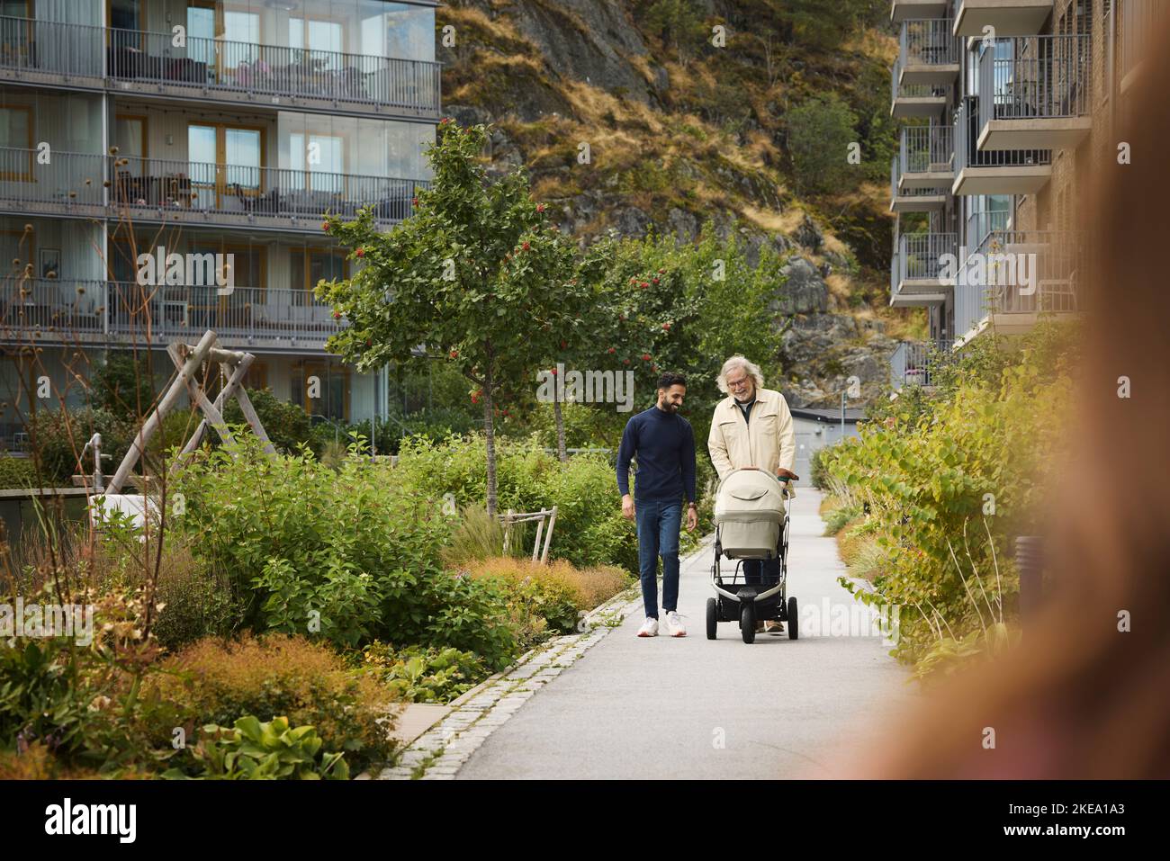 Men with baby stroller walking in residential area Stock Photo - Alamy