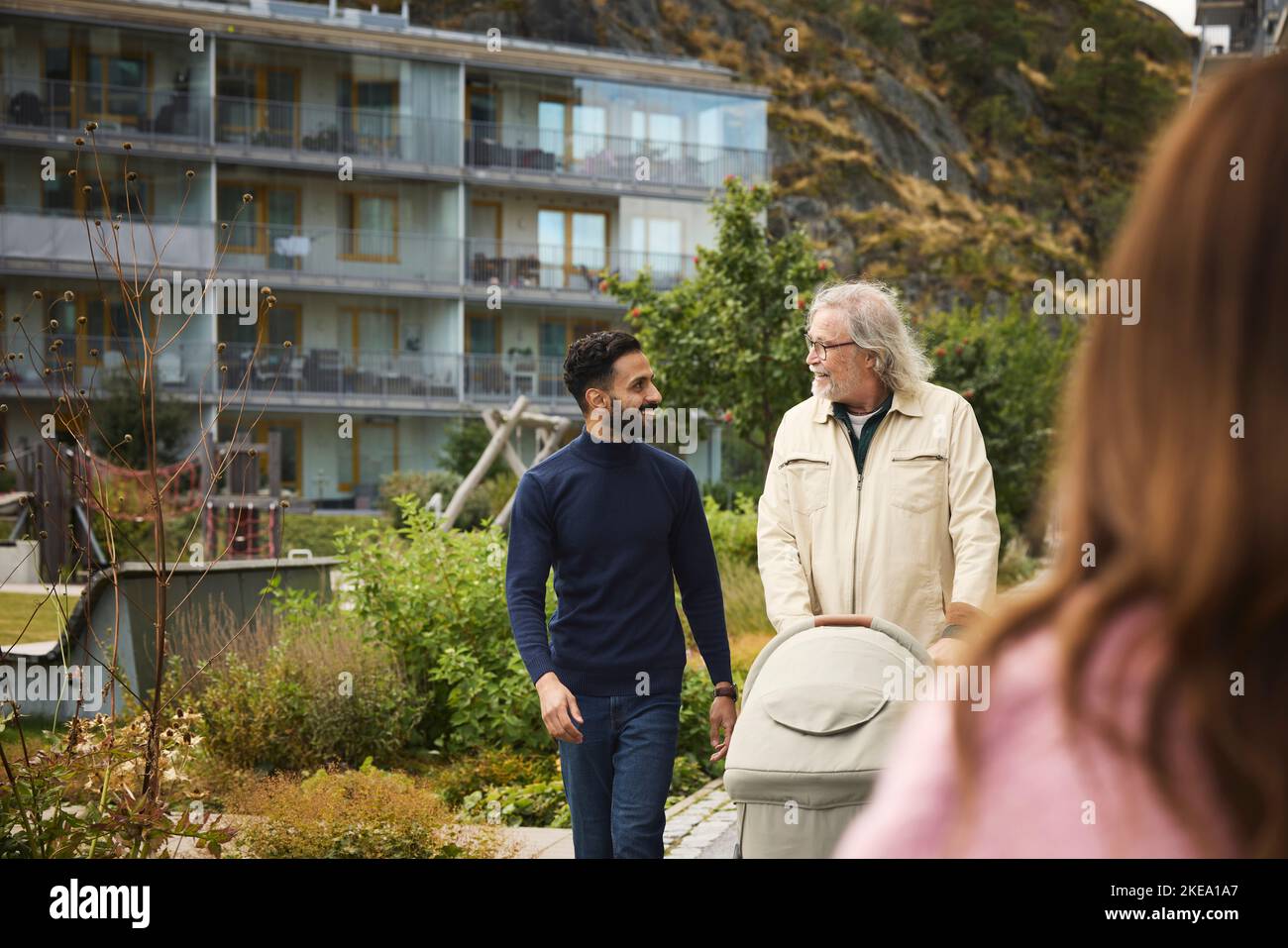 Men with baby stroller walking in residential area Stock Photo - Alamy