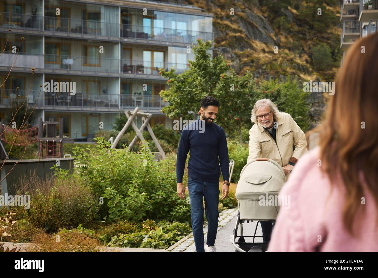 Men with baby stroller walking in residential area Stock Photo - Alamy