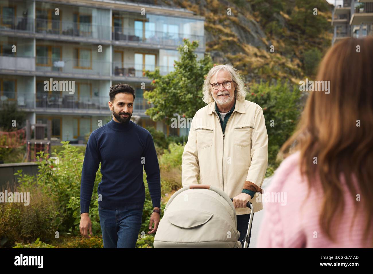 Men with baby stroller walking in residential area Stock Photo - Alamy