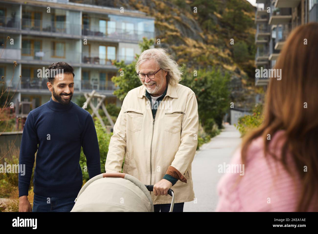 Men with baby stroller walking in residential area Stock Photo - Alamy