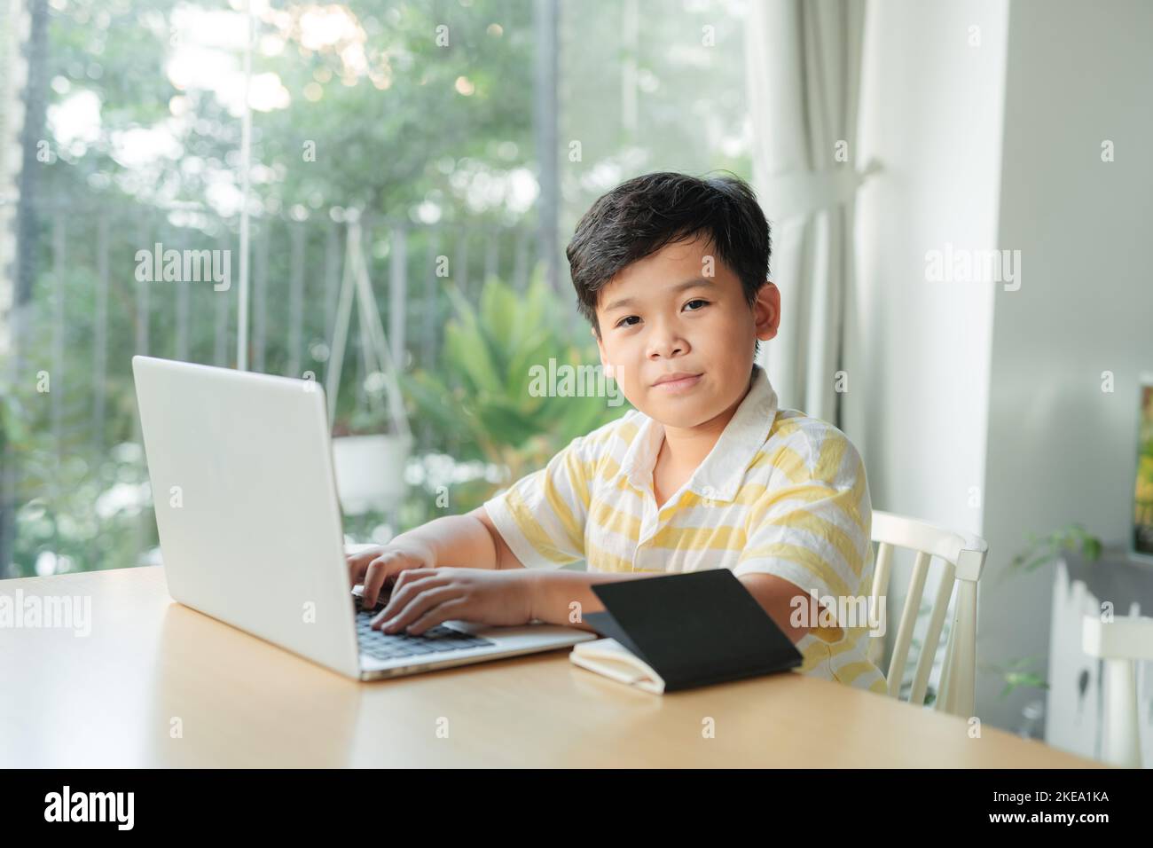 Little boy using laptop studying math during his online lesson at home ...