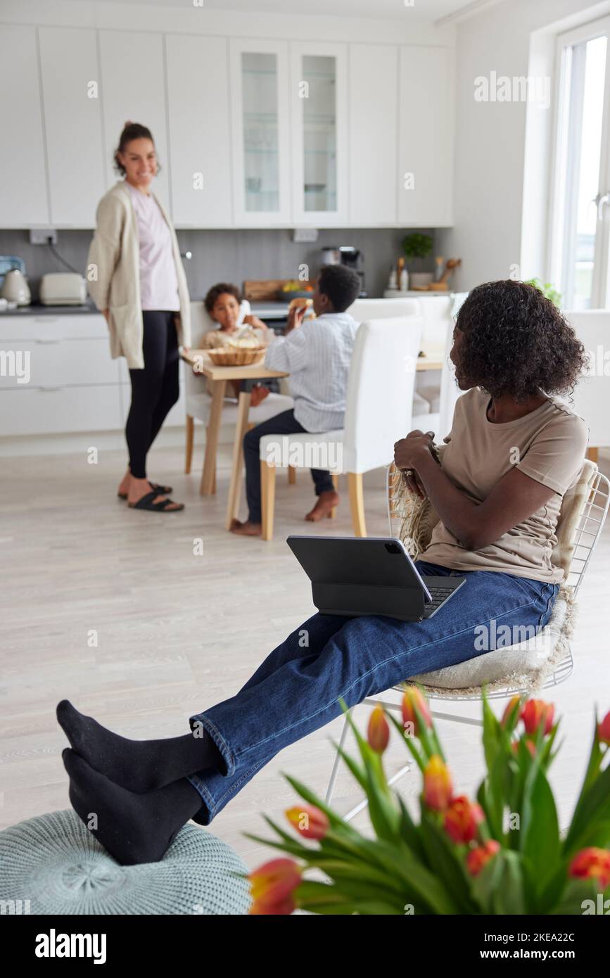 Family working and having meal at home Stock Photo - Alamy