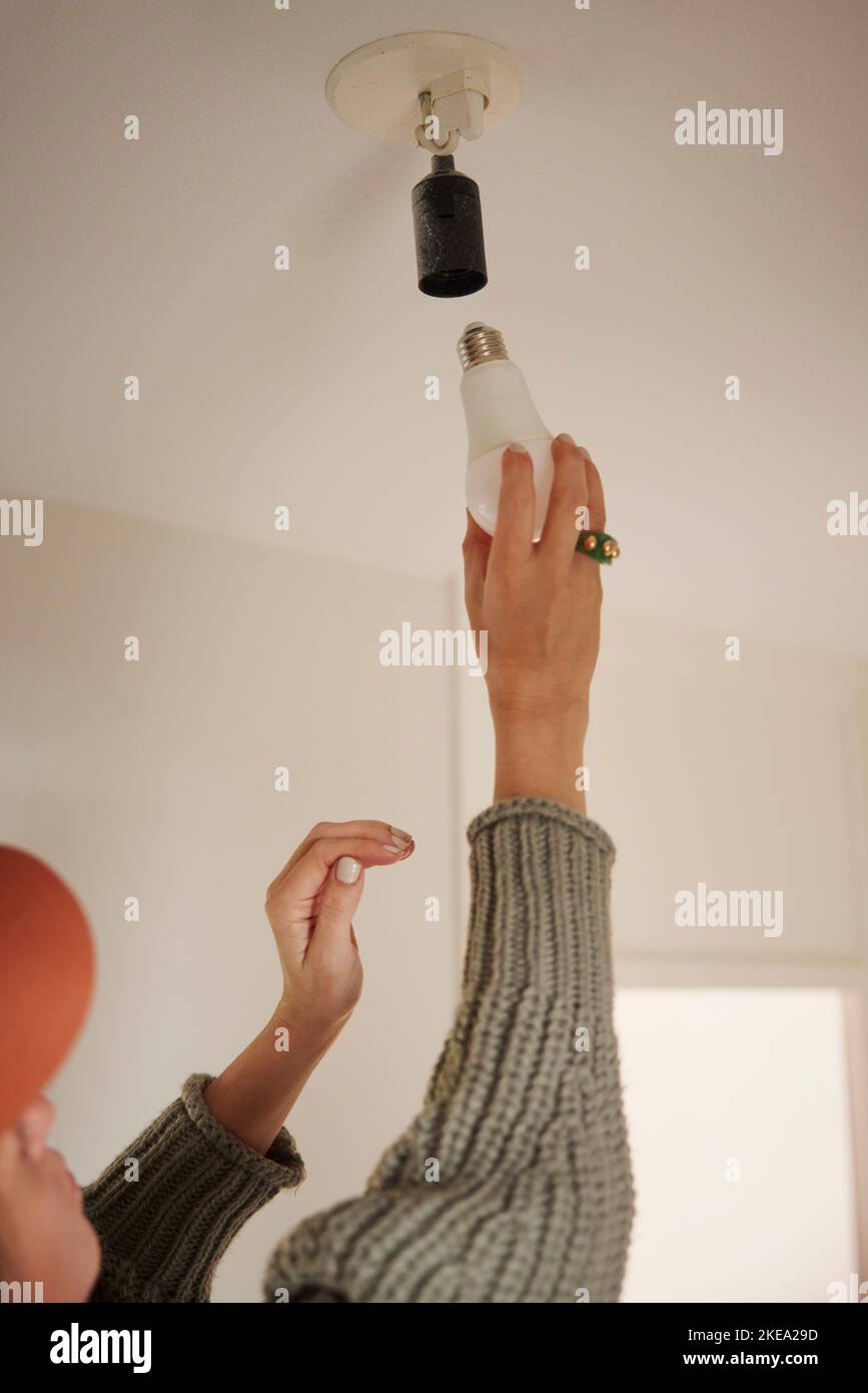 Woman changing light bulb Stock Photo - Alamy