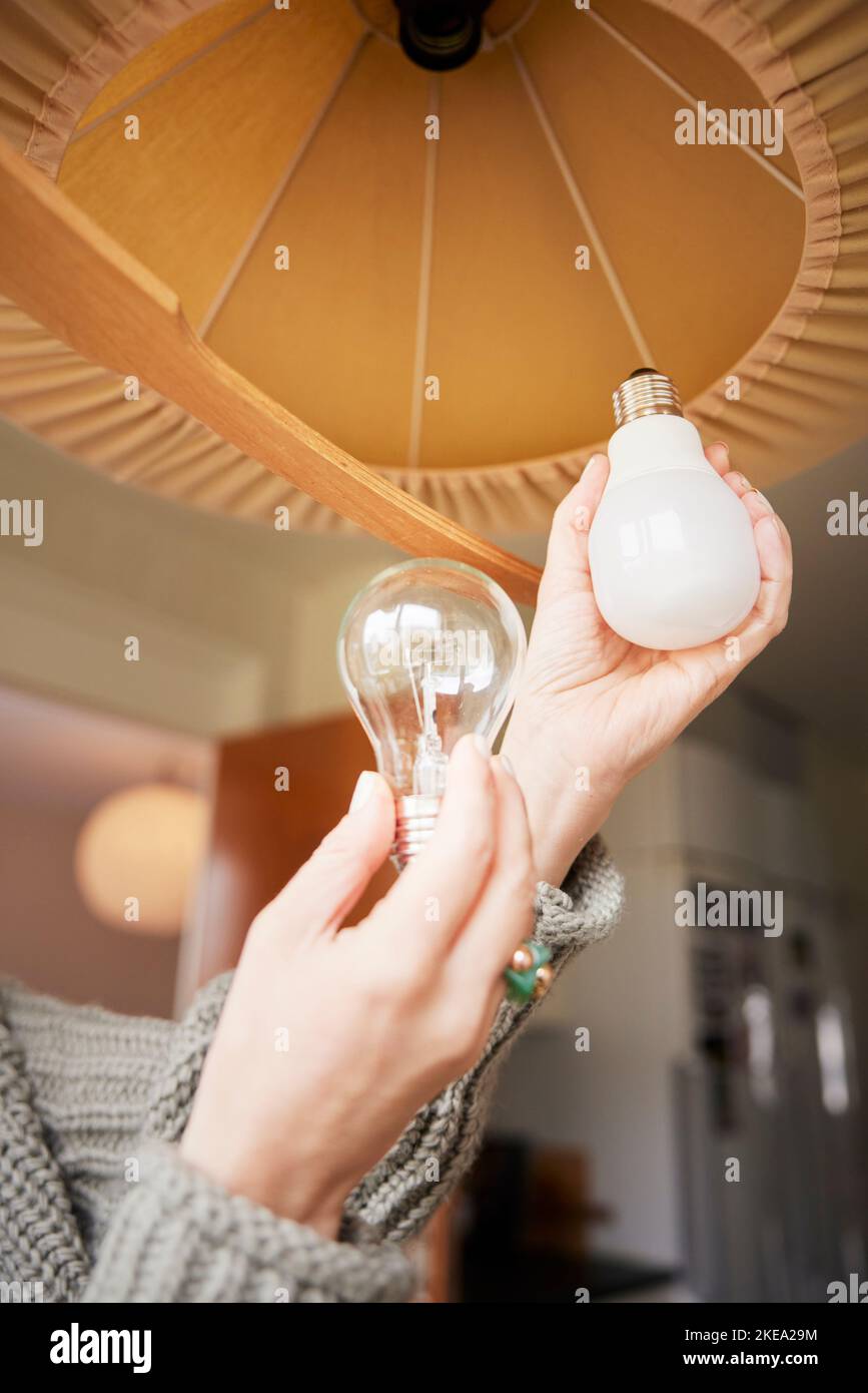 Woman's hands changing light bulb Stock Photo - Alamy