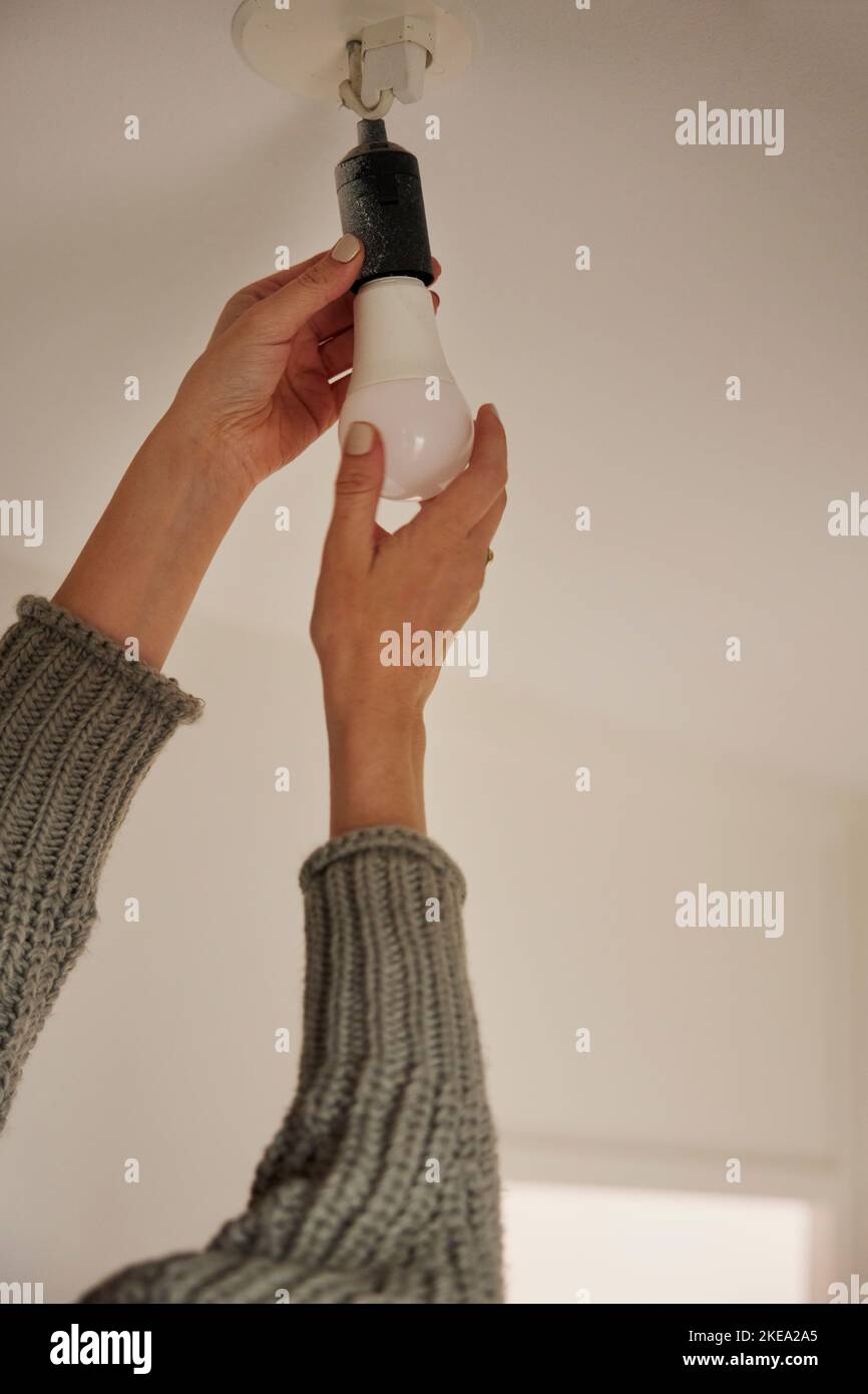 Woman's hands changing light bulb Stock Photo - Alamy