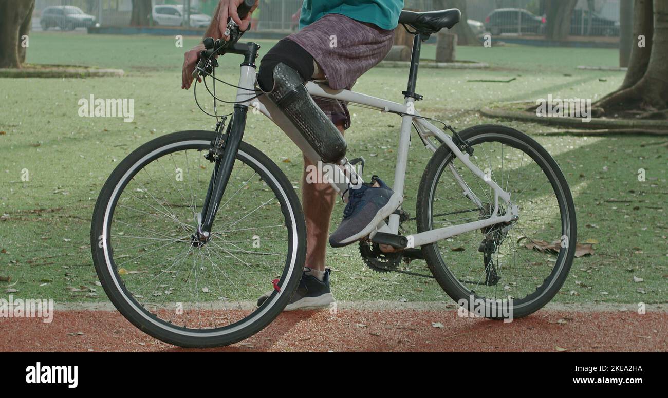 One middle aged disabled man on bicycle outside with prosthetic leg ...