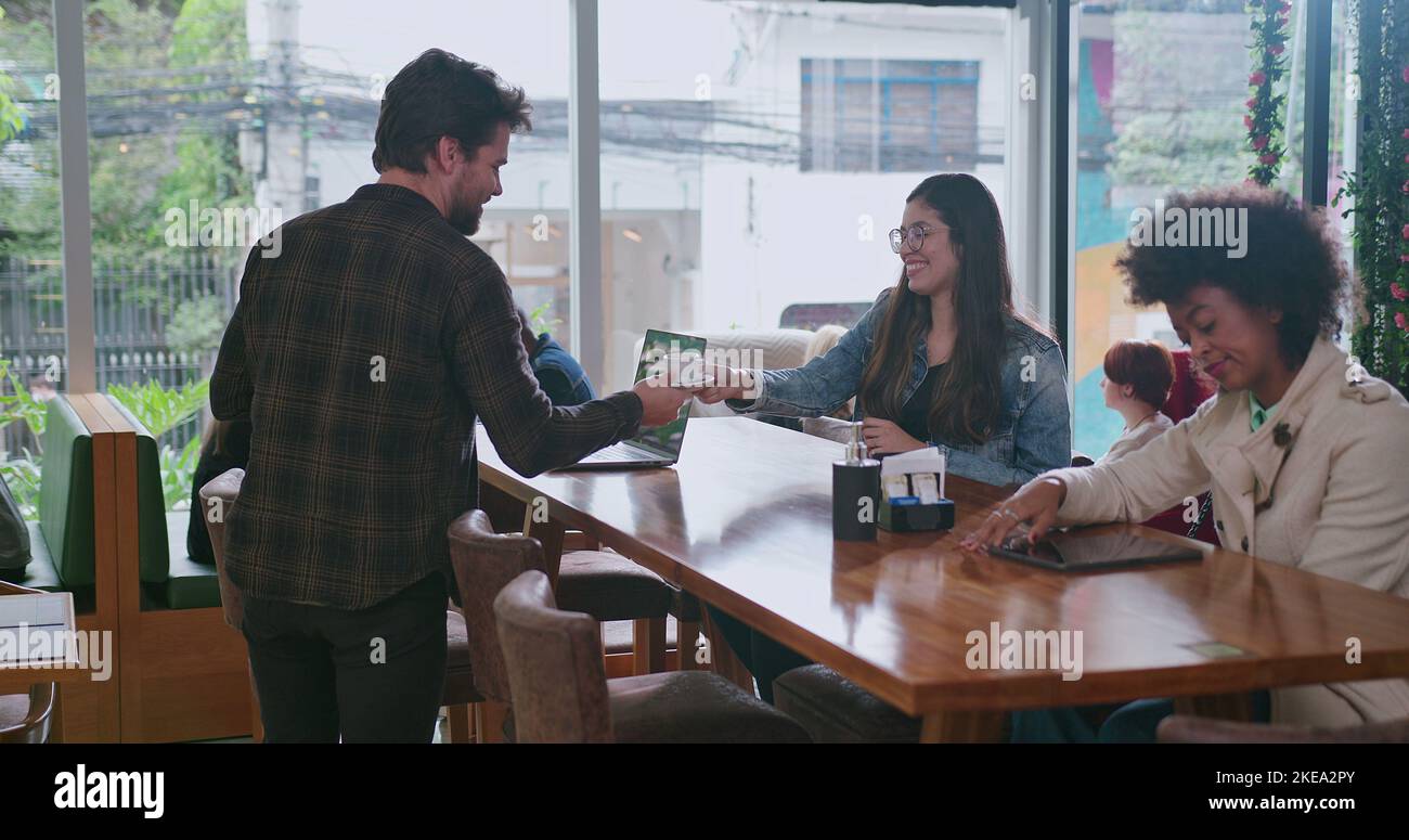 Happy male customer getting up from table and picking up two orders of ...