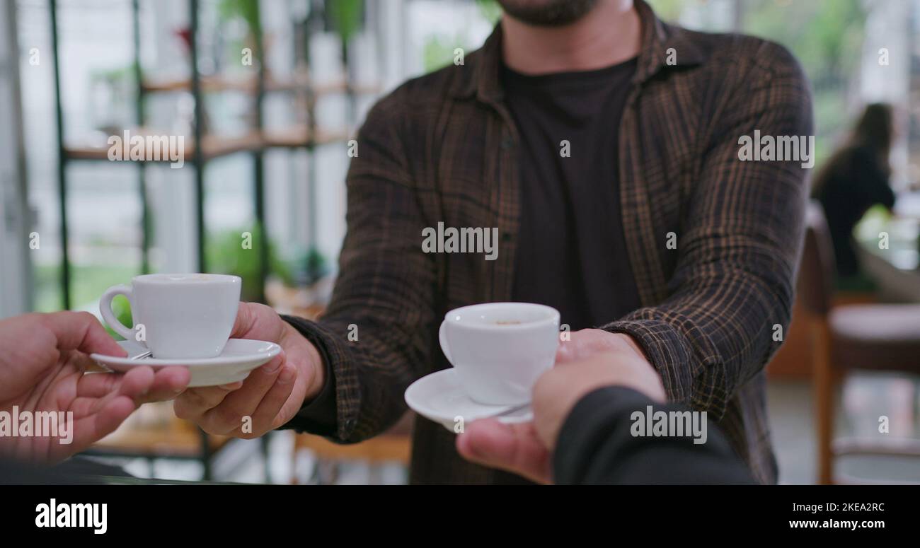 Happy male customer getting up from table and picking up two orders of ...